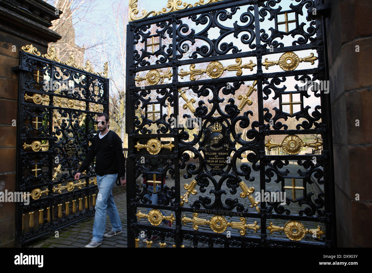 Man walking through the elaborate main gates to the Necropolis in ...