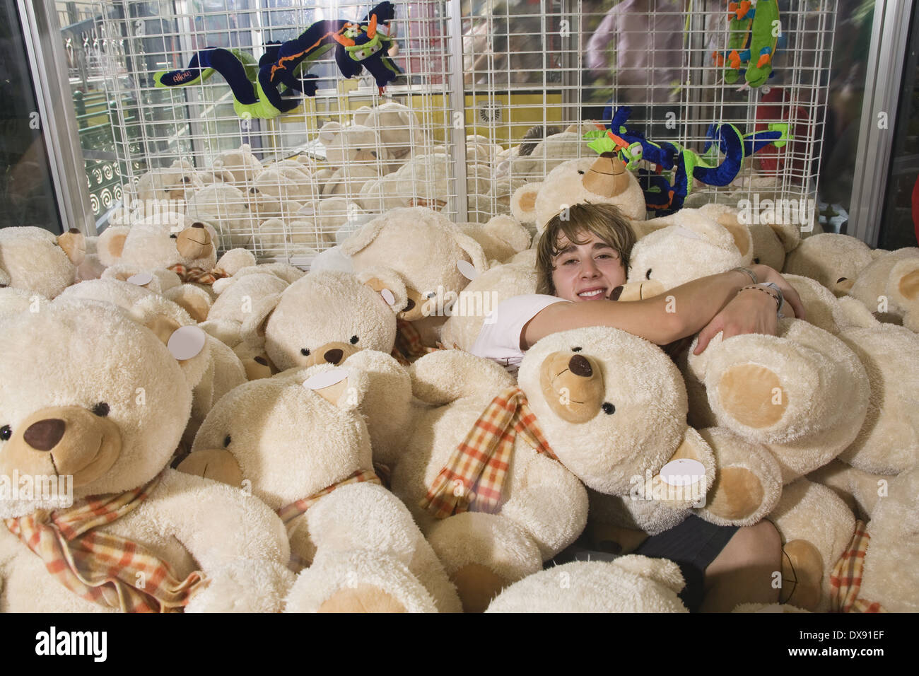 Male teenager among teddy bears in arcade Stock Photo - Alamy
