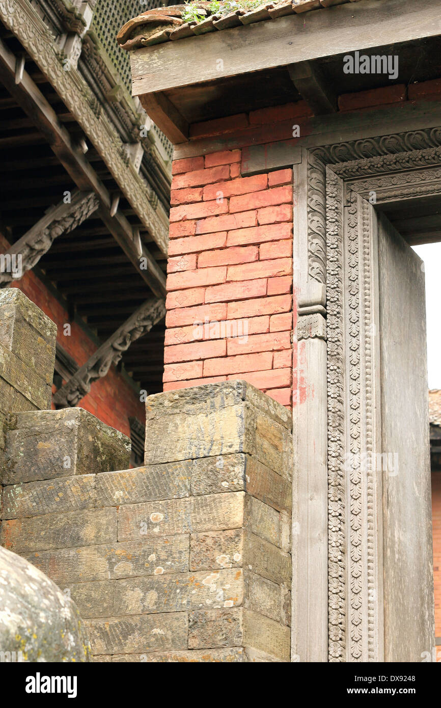 Carved wood door jambs and lintel on the red brick wall surrounding the ...
