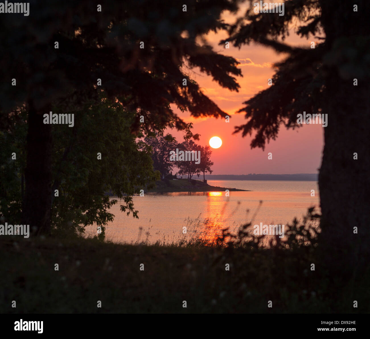 Sunset over the Ottawa. A red ball of a sun sets over the Ottawa River ...