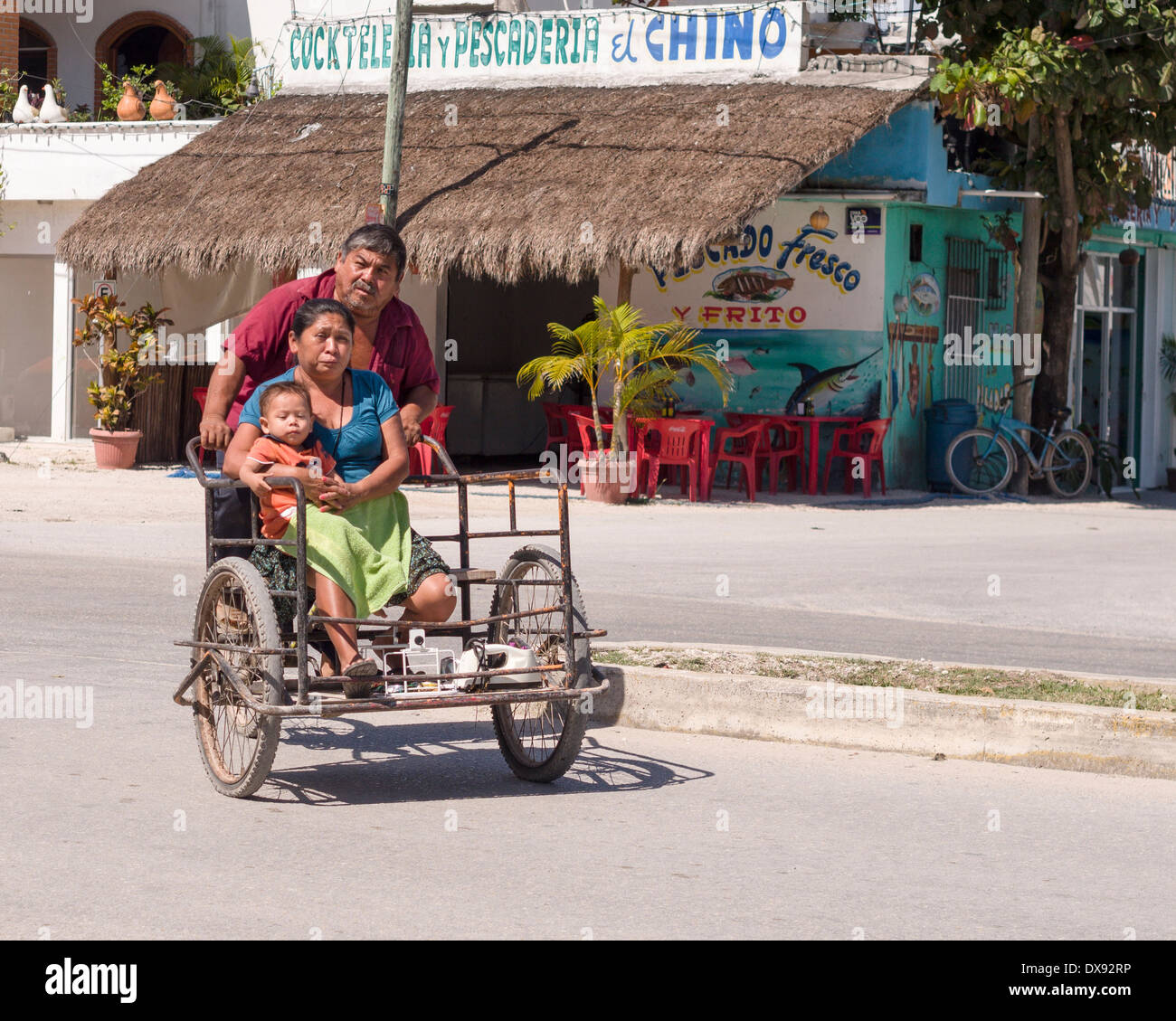 Family Transportation: tricycle. A multigenerational family rides down ...
