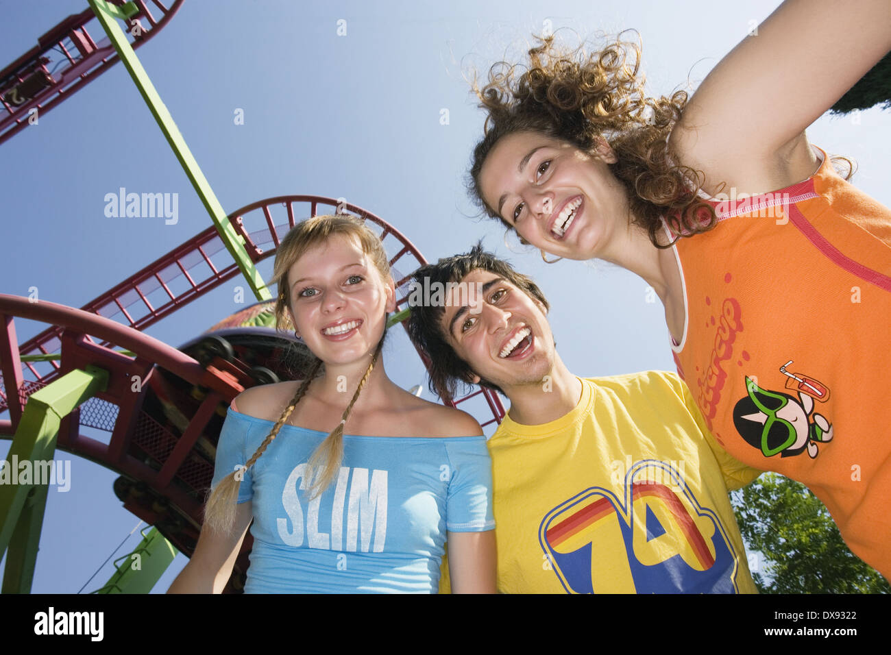 Teenagers posing at roller coaster at amusement park Stock Photo - Alamy
