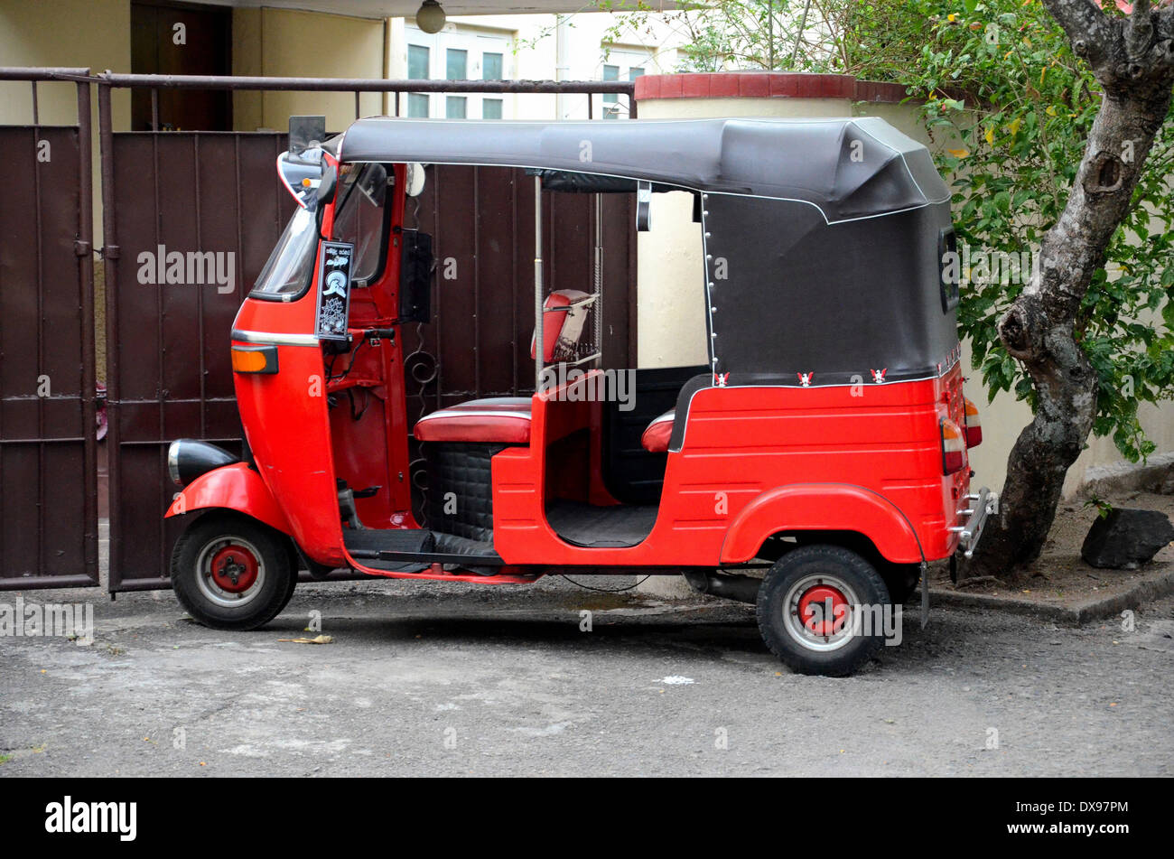 Red three wheeler tuk tuk rickshaw taxi parked on side street in ...