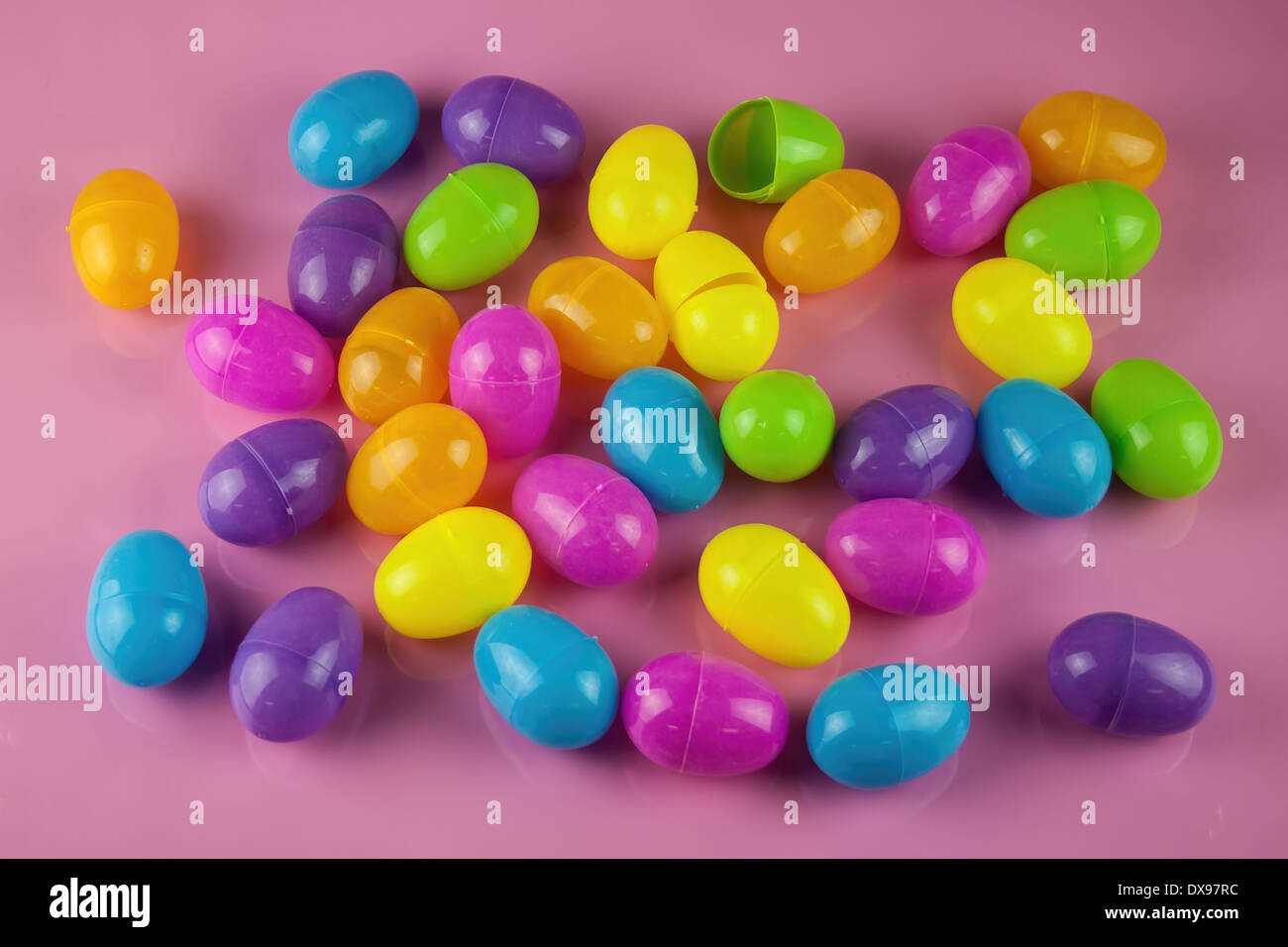 a group of Plastic Easter Egg shells on a glossy pink background. cute ...