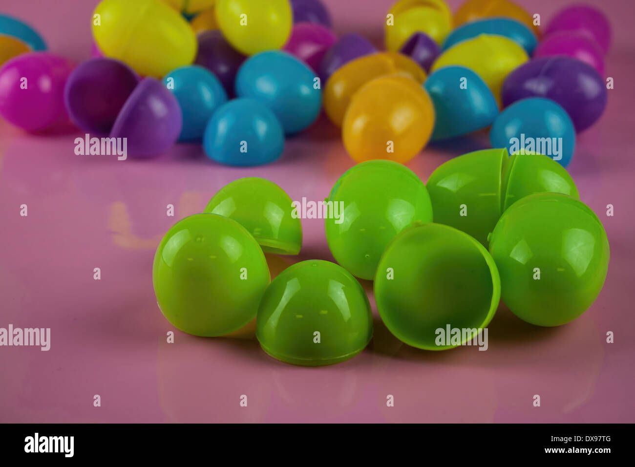 a group of Plastic Easter Egg shells on a glossy pink background. cute ...
