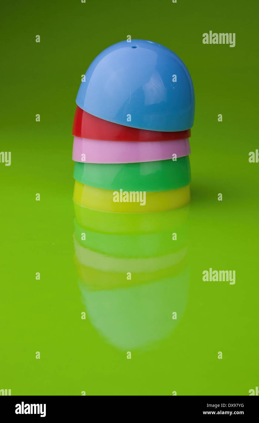 Five half shell plastic Easter egg shells, on a glossy green background ...