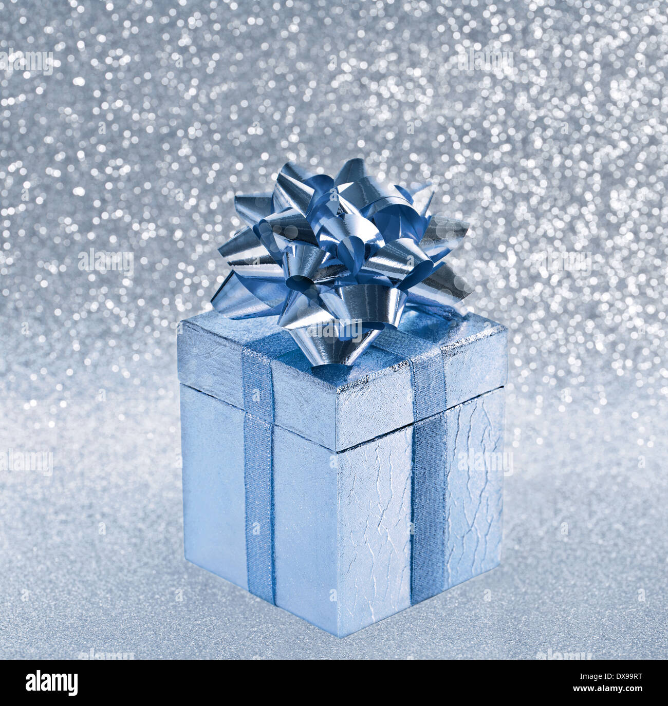 silver blue gift box with ribbon over blurred shiny background. festive ...