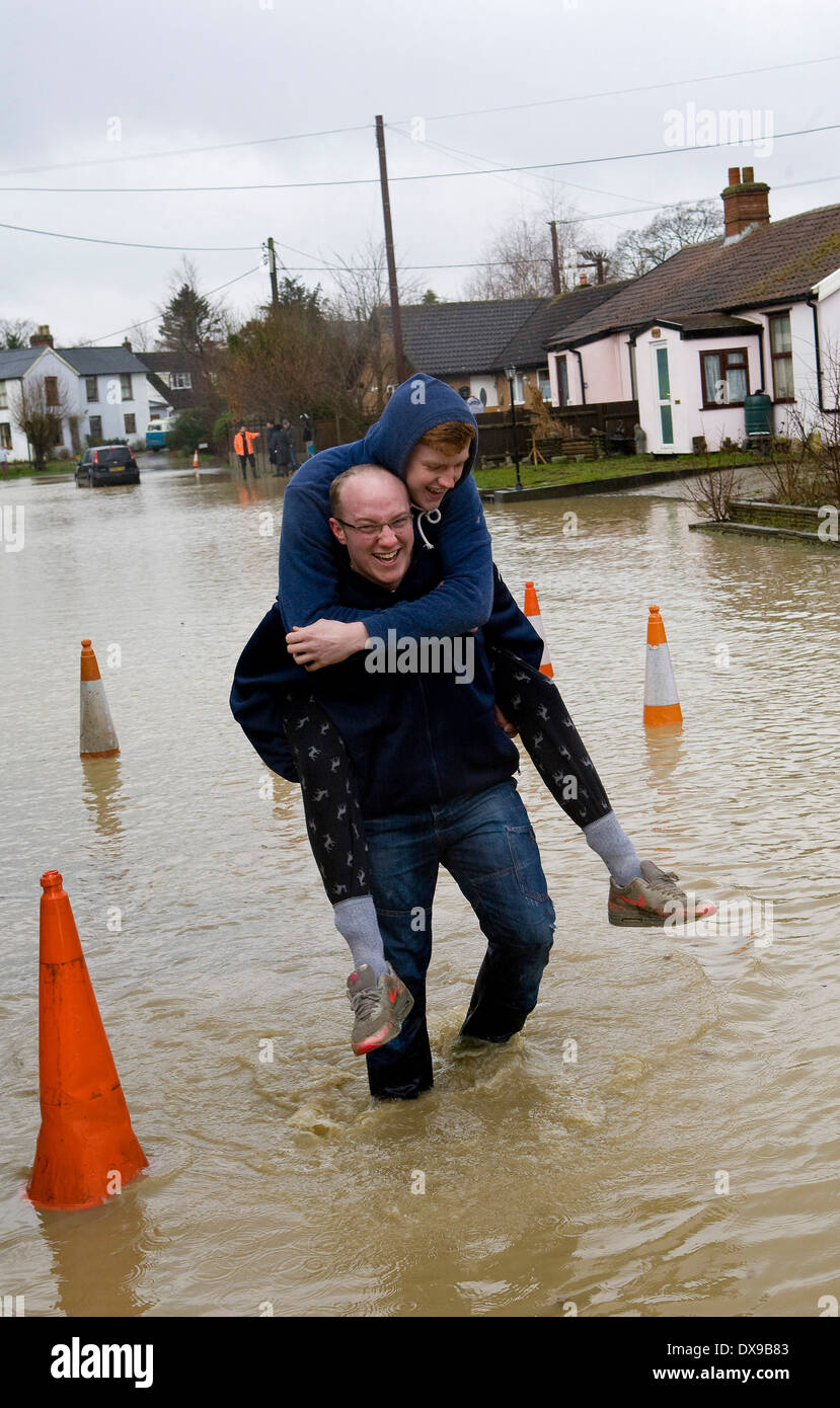 Residents struggle through the flooded village of Steeple Bumpstead in ...