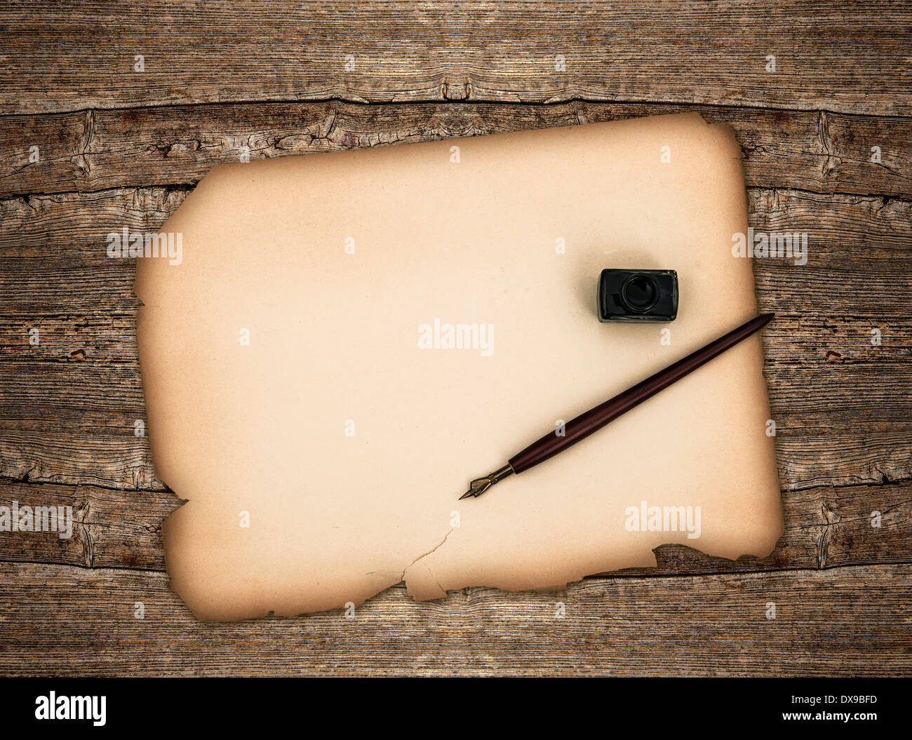 old paper sheet and antique ink pen over rustic wooden background ...