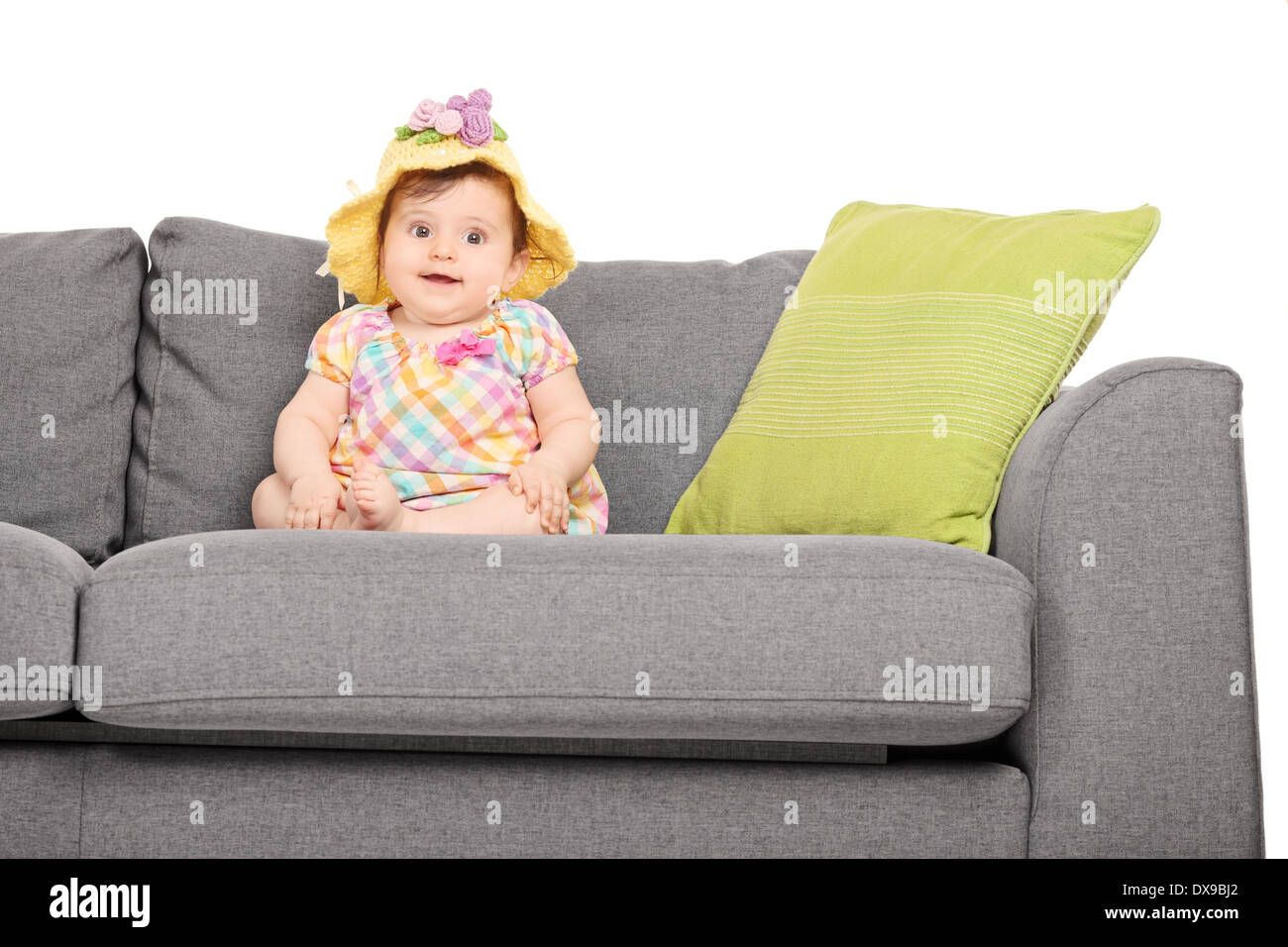 Adorable little baby seated on a couch Stock Photo - Alamy