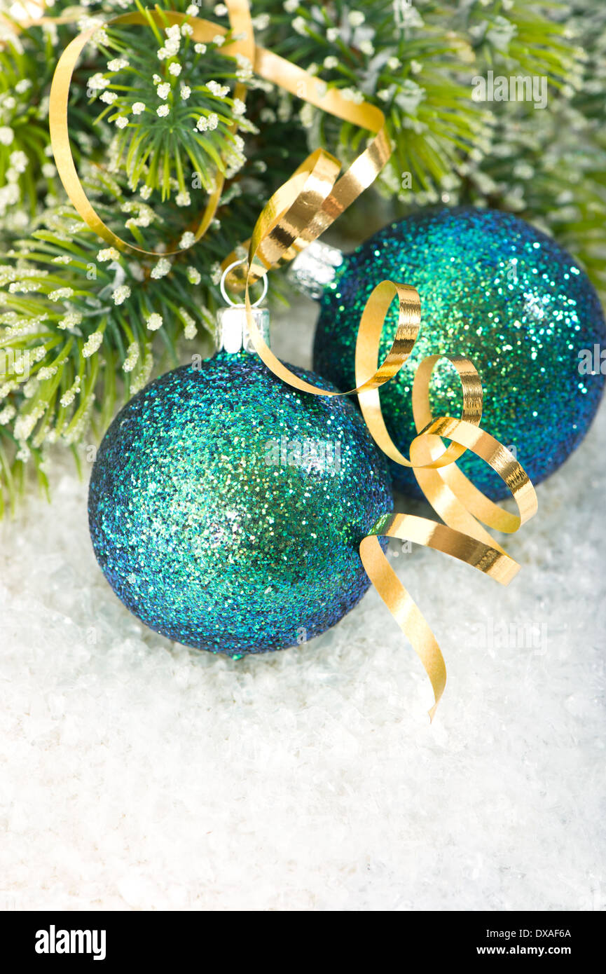 blue christmas baubles with christmas tree branch in snow decoration ...
