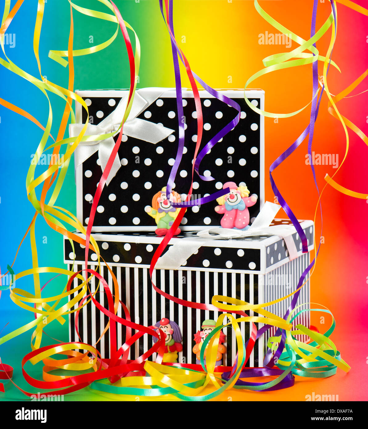 Colorful party or holiday decoration. gifts and sugar clowns on rainbow ...