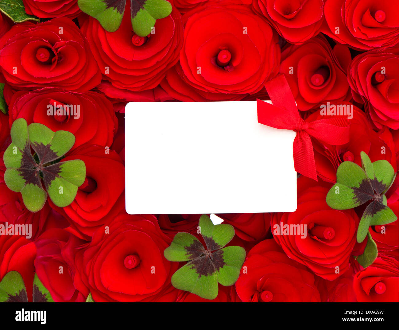red roses with green leaves of clover and white card for your text ...