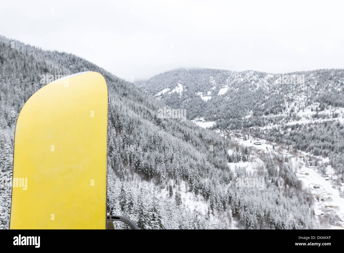 snowboard on the way to the top of the mountain in a cable car at high ...