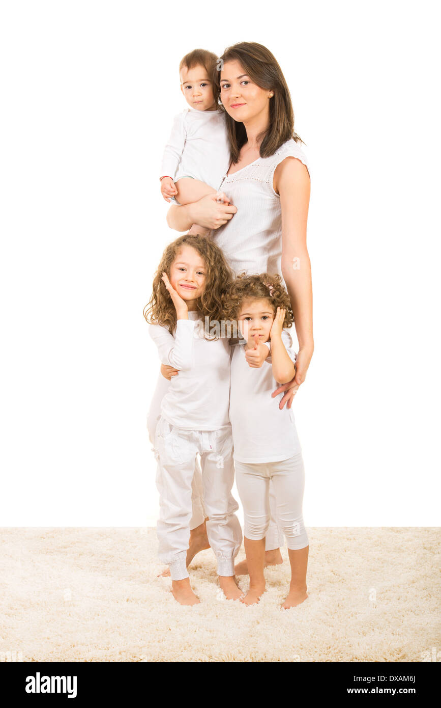 Happy mother with three children posing home and standing on carpet ...