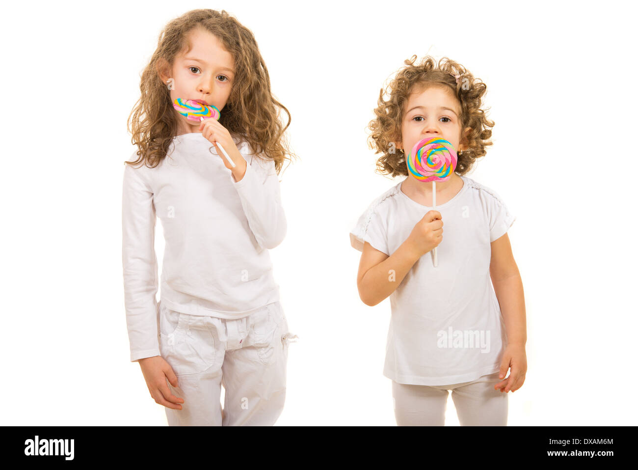 Two little girls eating lollipops isolated on white background Stock ...