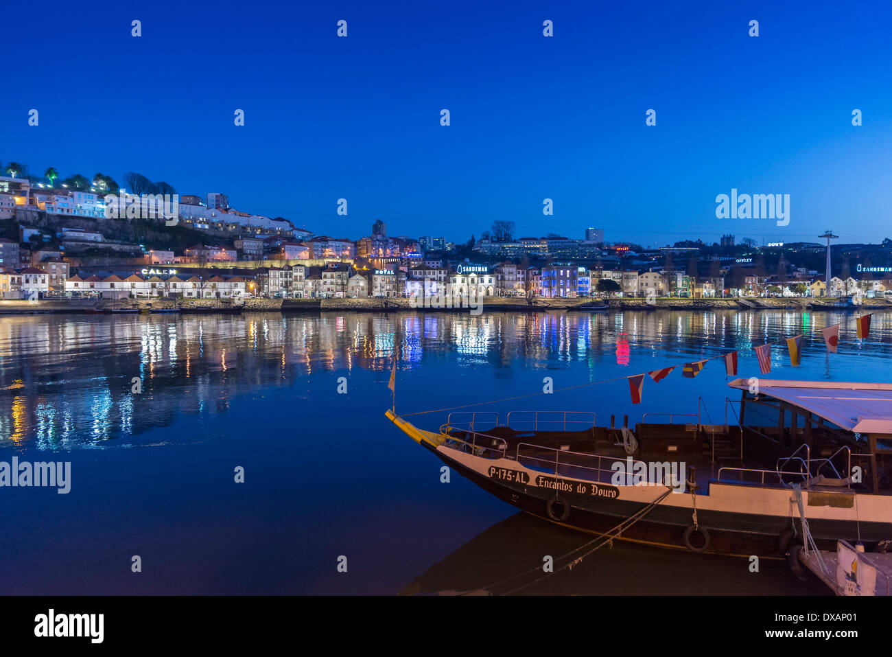 Colorful view of sunset along the riverfront with lights reflecting in ...