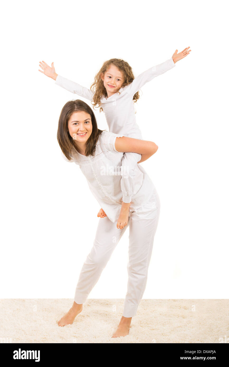 Mother and daughter having fun home and offering to her girl piggy back ...