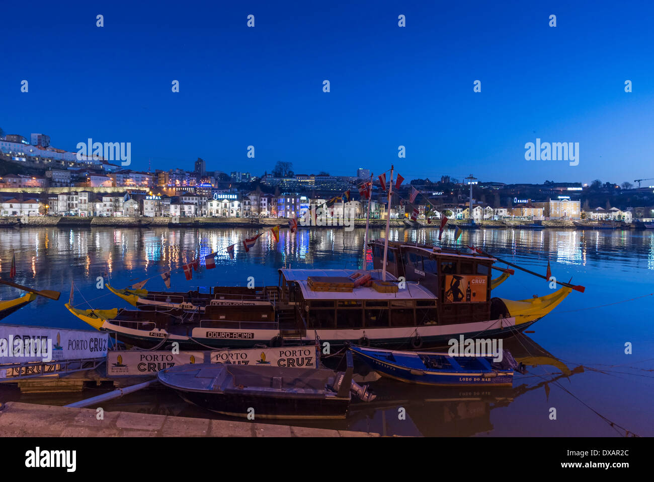 Colorful view of sunset along the riverfront with lights reflecting in ...