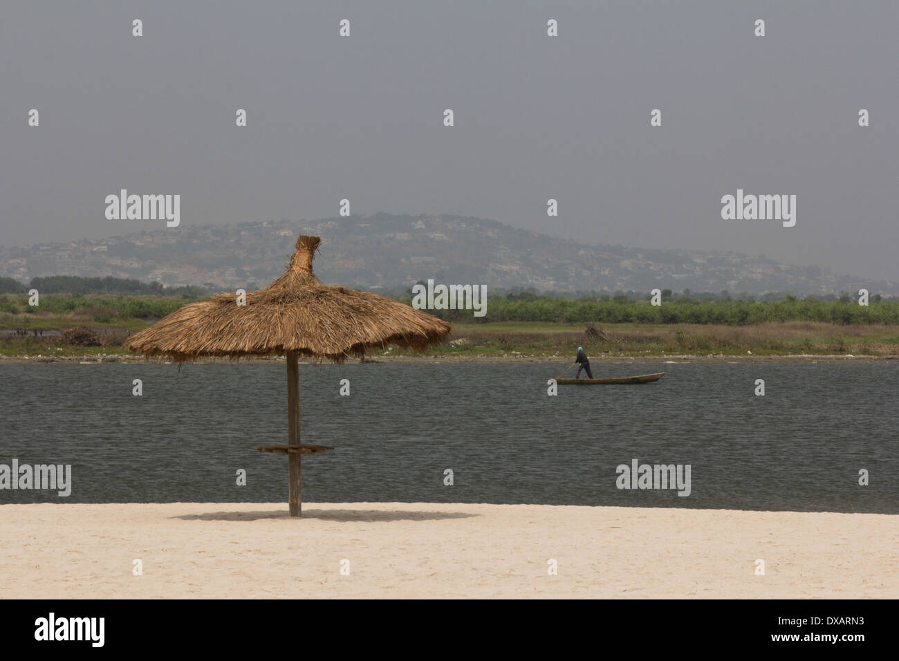 Thatched Beach Umbrella in Bojo Beach Resort with man poling a canoe ...