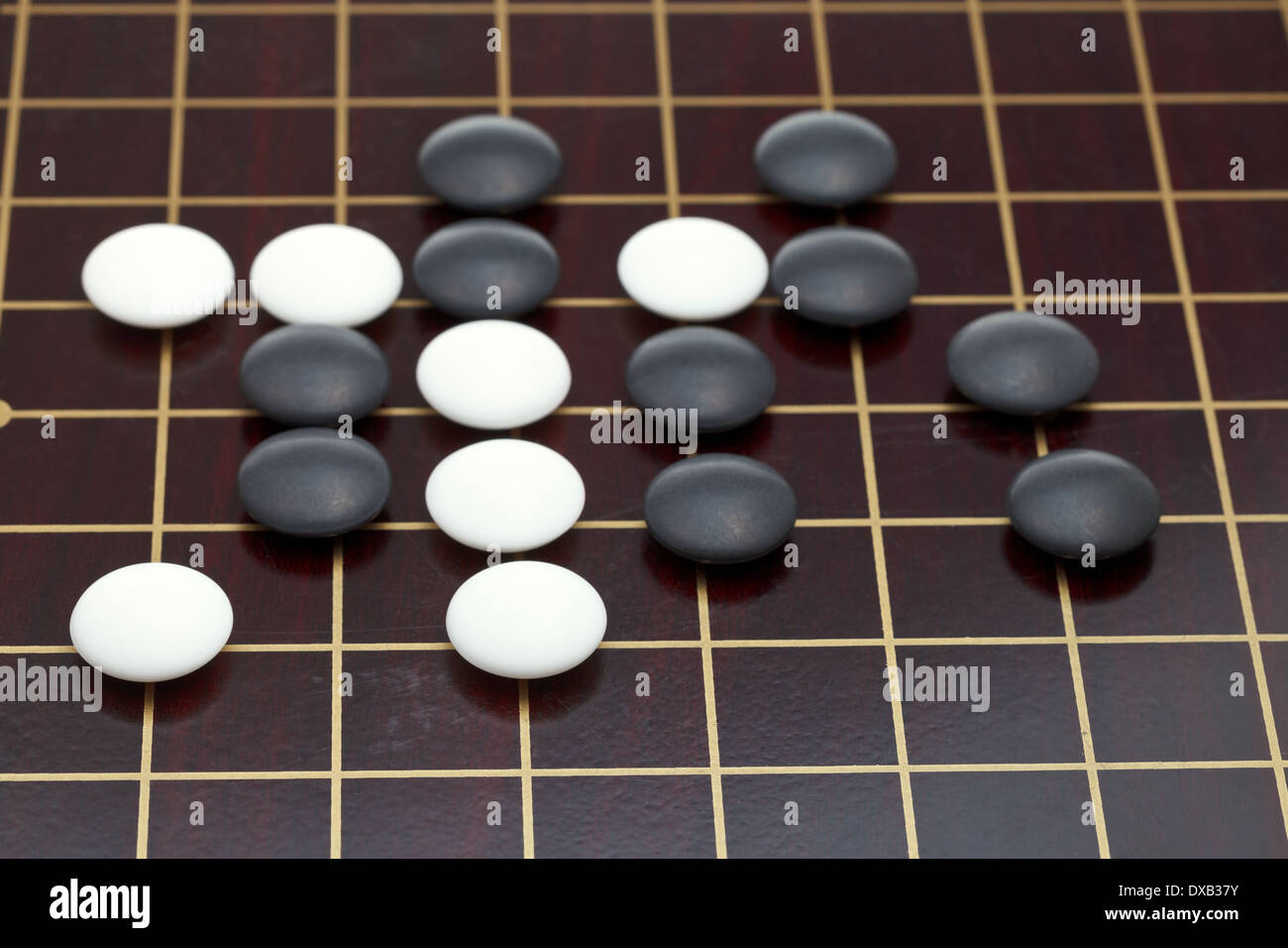 position of stones during go game playing on wooden goban Stock Photo ...