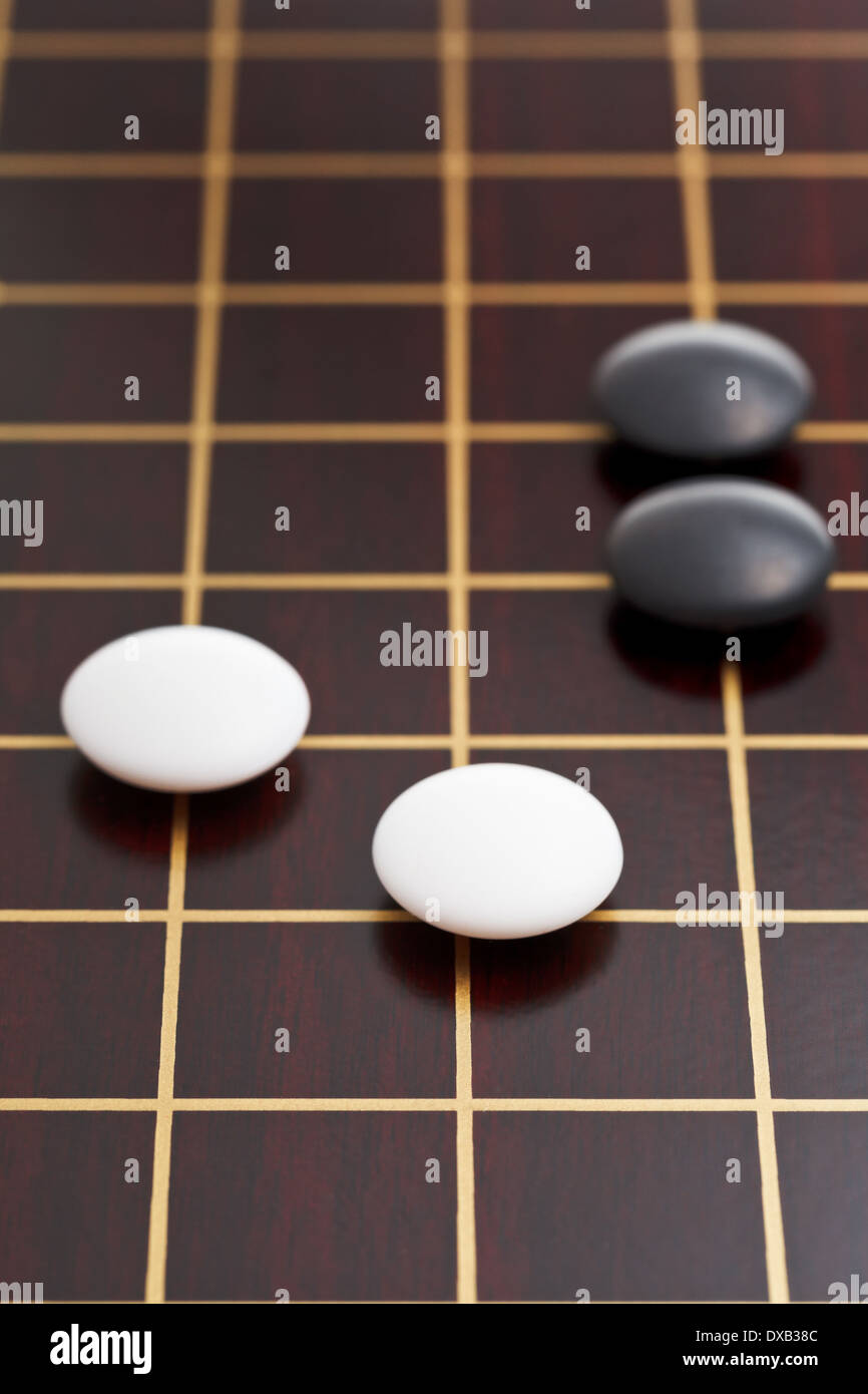 black and white stones during go game playing on goban close up Stock ...