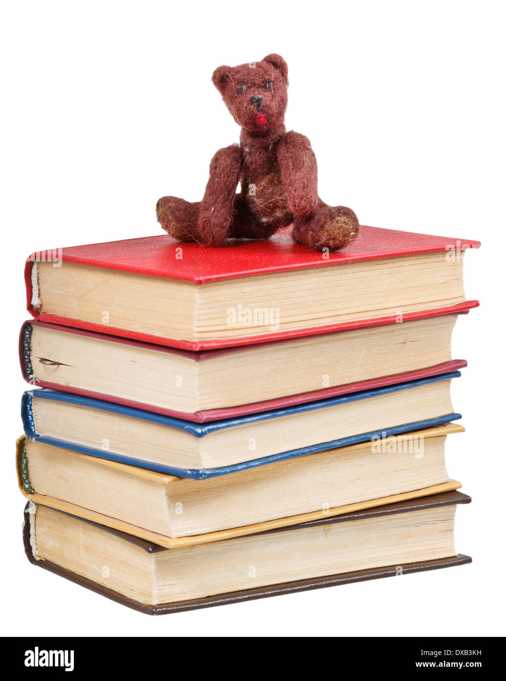 felt soft toy bear sits on stack of books isolated on white background ...