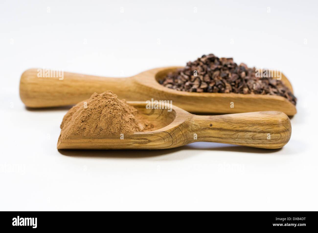 Scoop of raw cocoa nibs and a scoop of raw cacao powder Stock Photo - Alamy