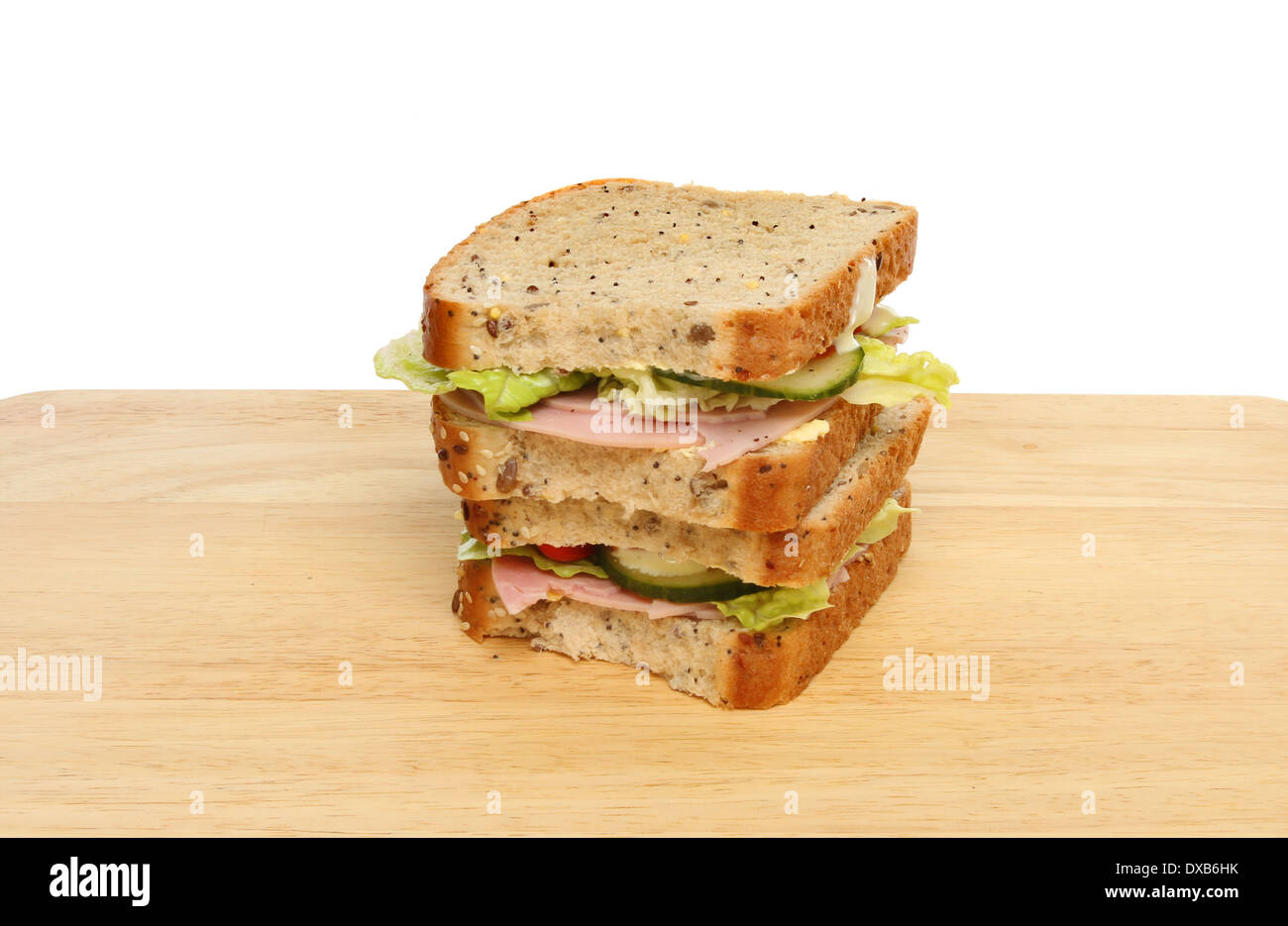 Stack of ham salad sandwiches on a wooden board against a white ...