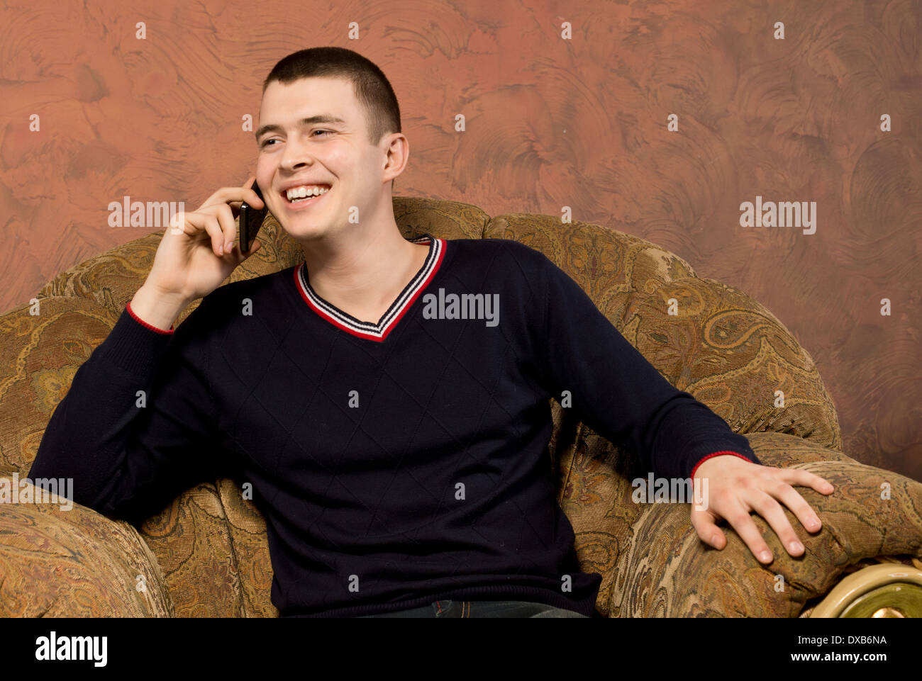Happy young man chatting on his mobile phone Stock Photo - Alamy