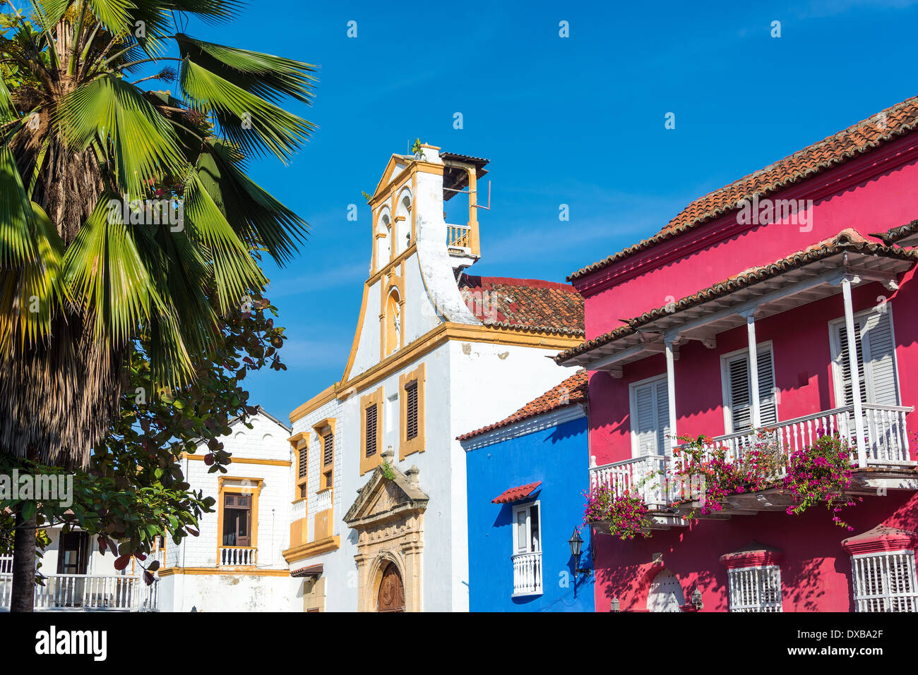 Historic white colonial church standing next to blue and pink historic ...