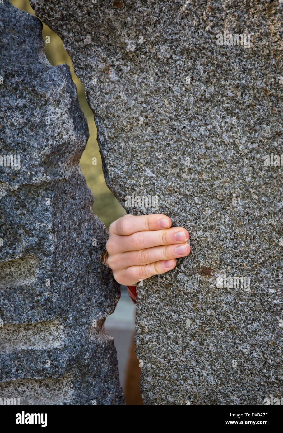 Hand Of A Child Grasps Through Gap In A Stone Wall Stock Photo - Alamy