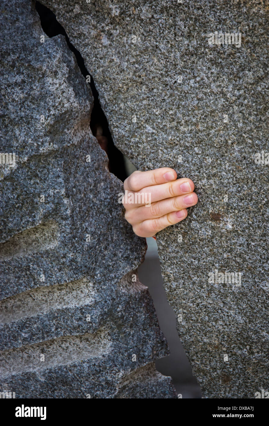 Hand Of A Child Grasps Through Gap In A Stone Wall Stock Photo - Alamy