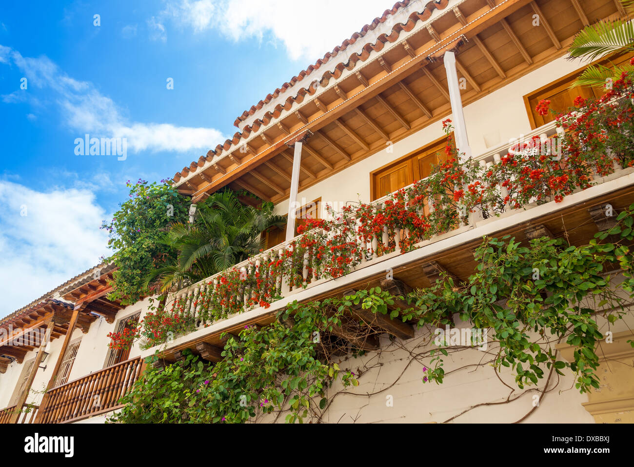 White colonial balcony in historic Cartagena, Colombia with red flowers ...
