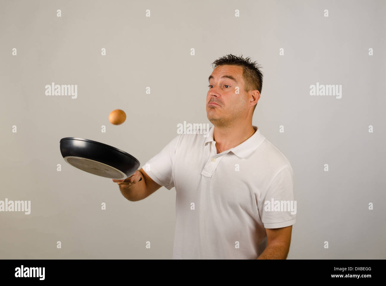 Guy facing the challenge to fry his first egg Stock Photo - Alamy