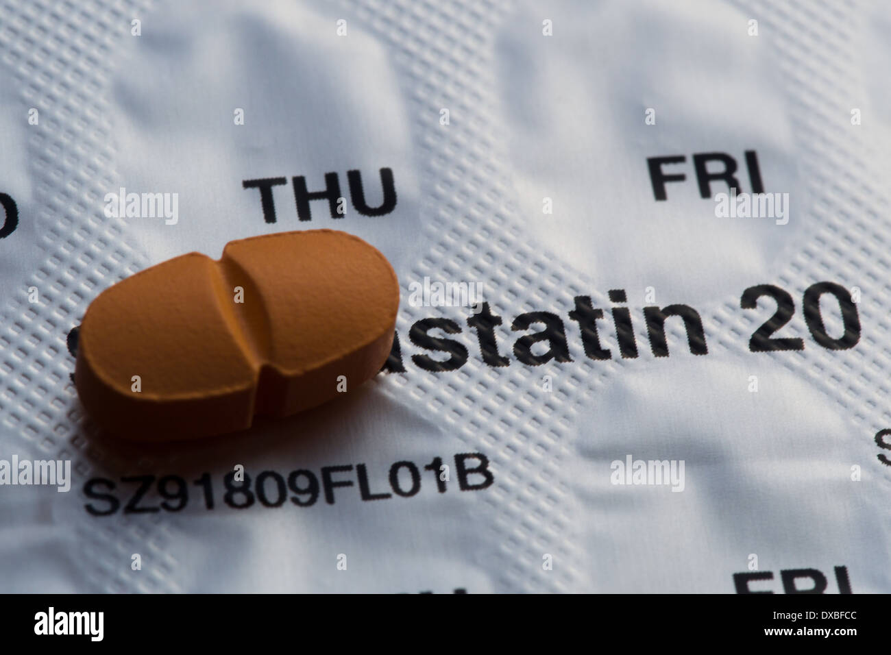 A statin tablet against a blister pack with the word Statin showing ...