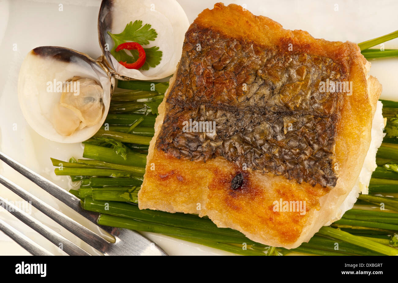 Crisp seared cod fillet on a bed of chives garnished with almejas ...