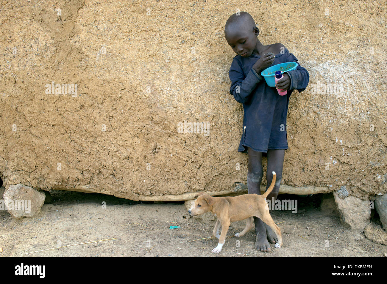African Boy eating with his dog Stock Photo - Alamy