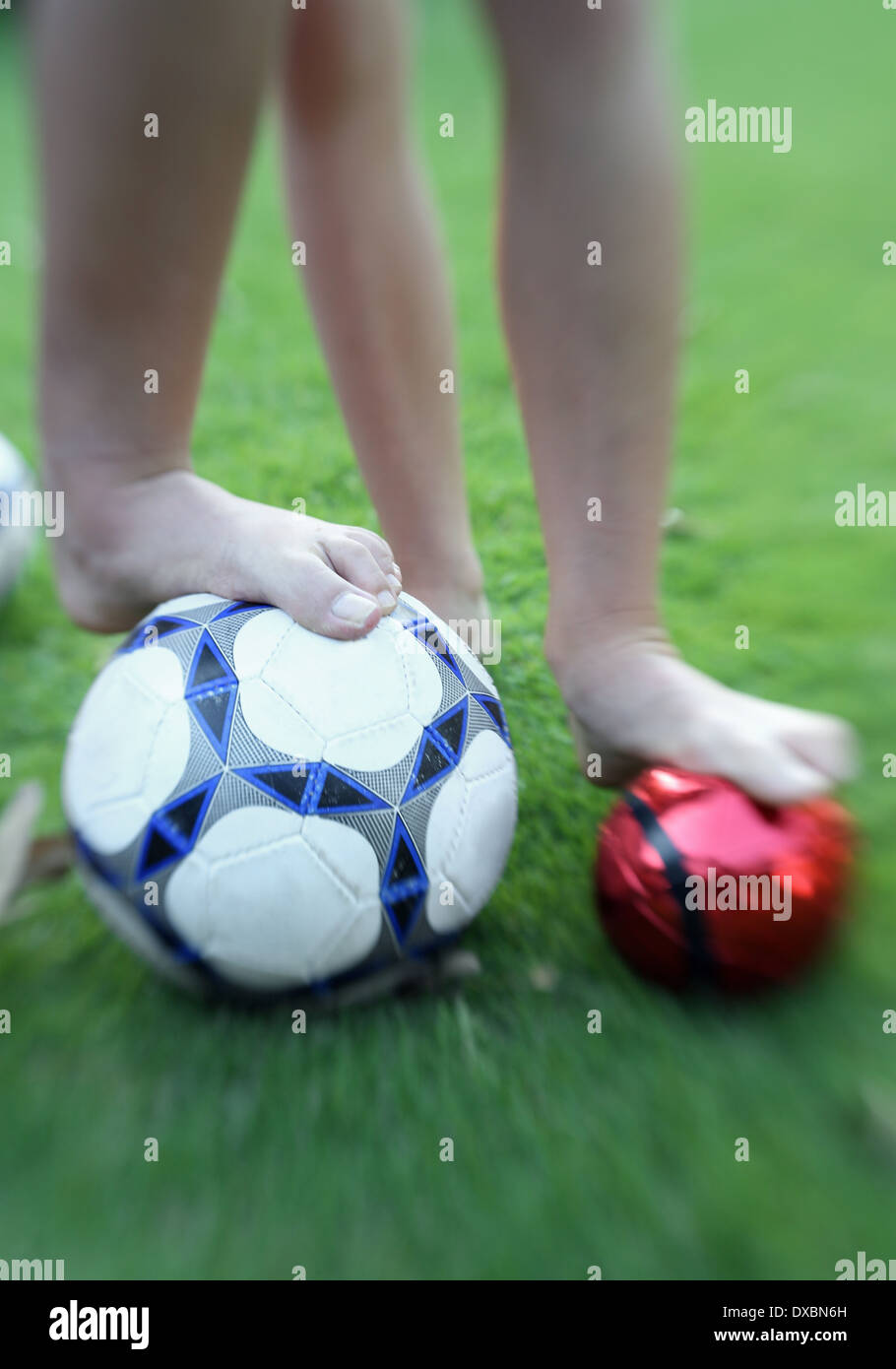 Two children's legs with balls Stock Photo - Alamy