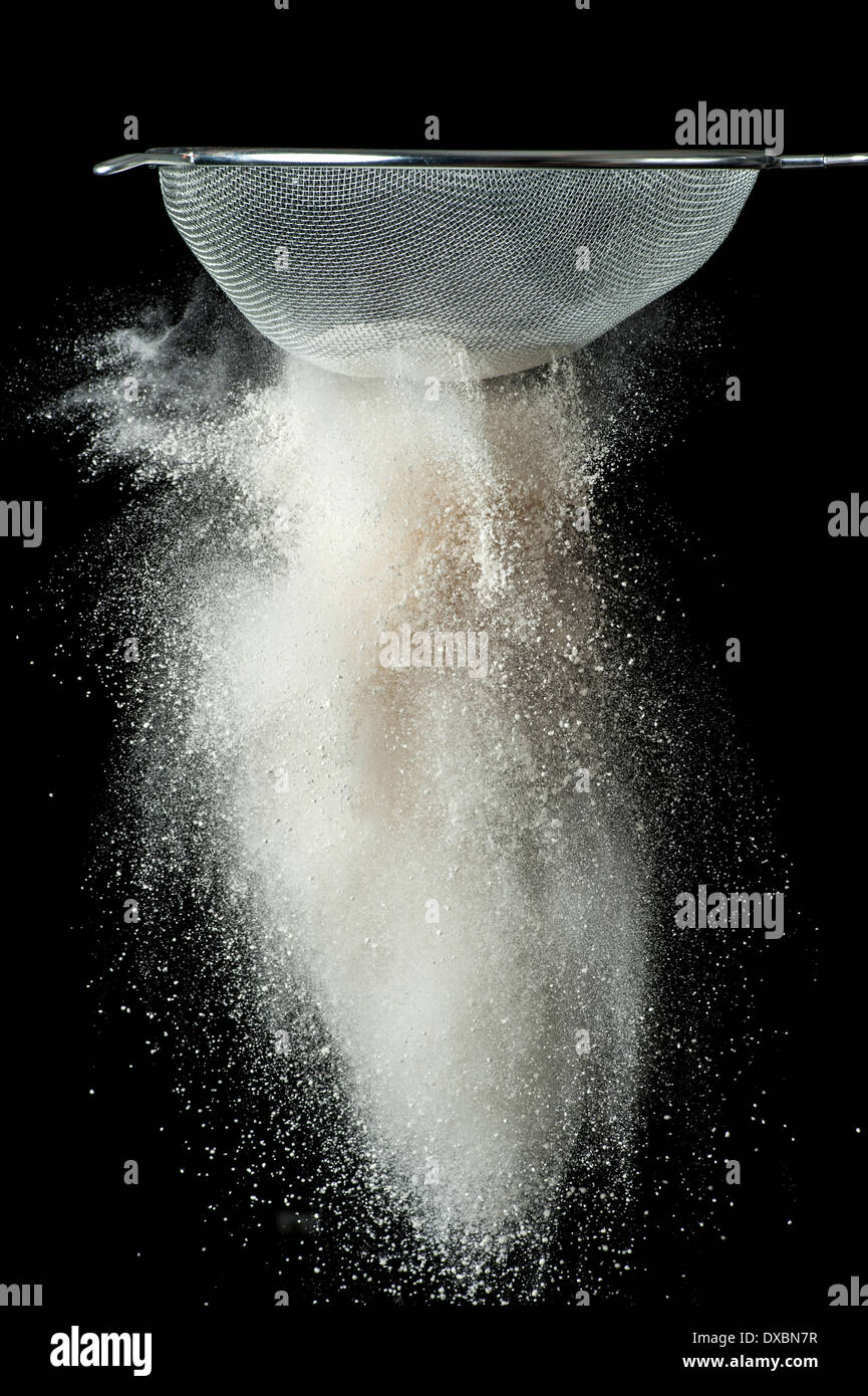 Metal kitchen sieve being used to sift flour Stock Photo - Alamy