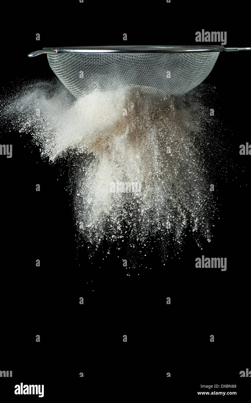 Metal kitchen sieve being used to sift flour Stock Photo - Alamy
