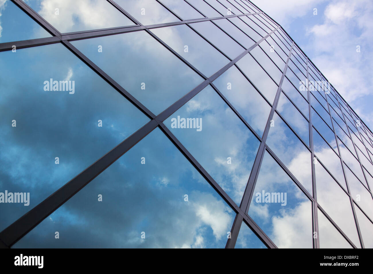 reflexions of clouds and blue sky in diagonal glass facade of modern ...