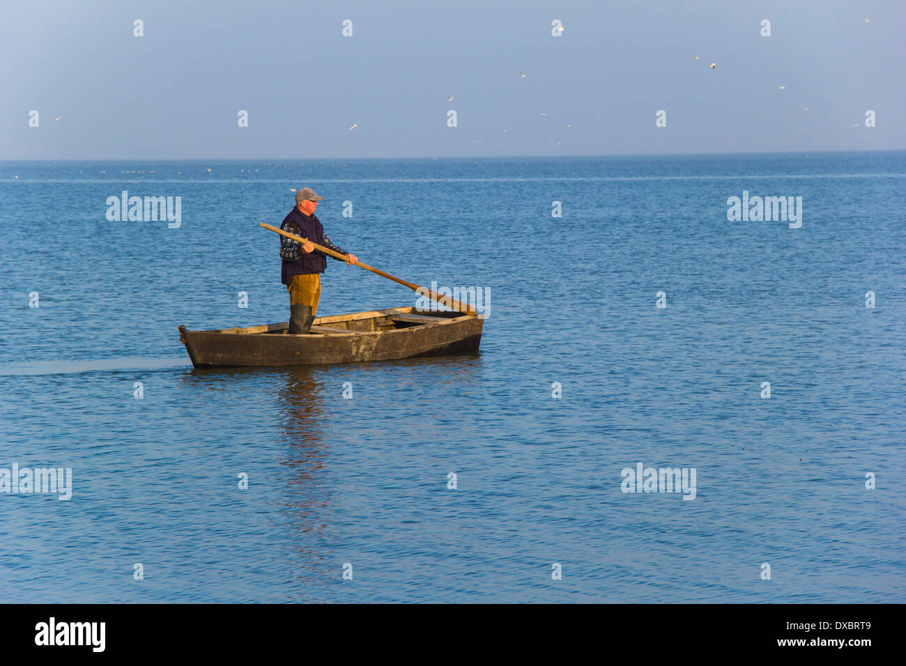 fisherman in boat on water Stock Photo - Alamy