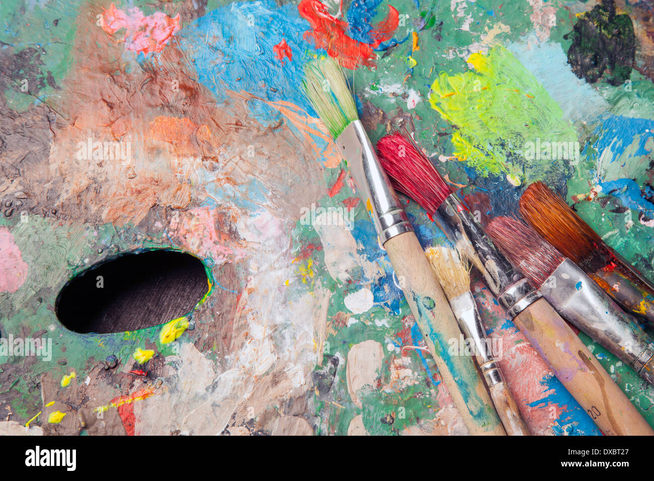 colorful palette full of paint spots and paint brushes Stock Photo - Alamy