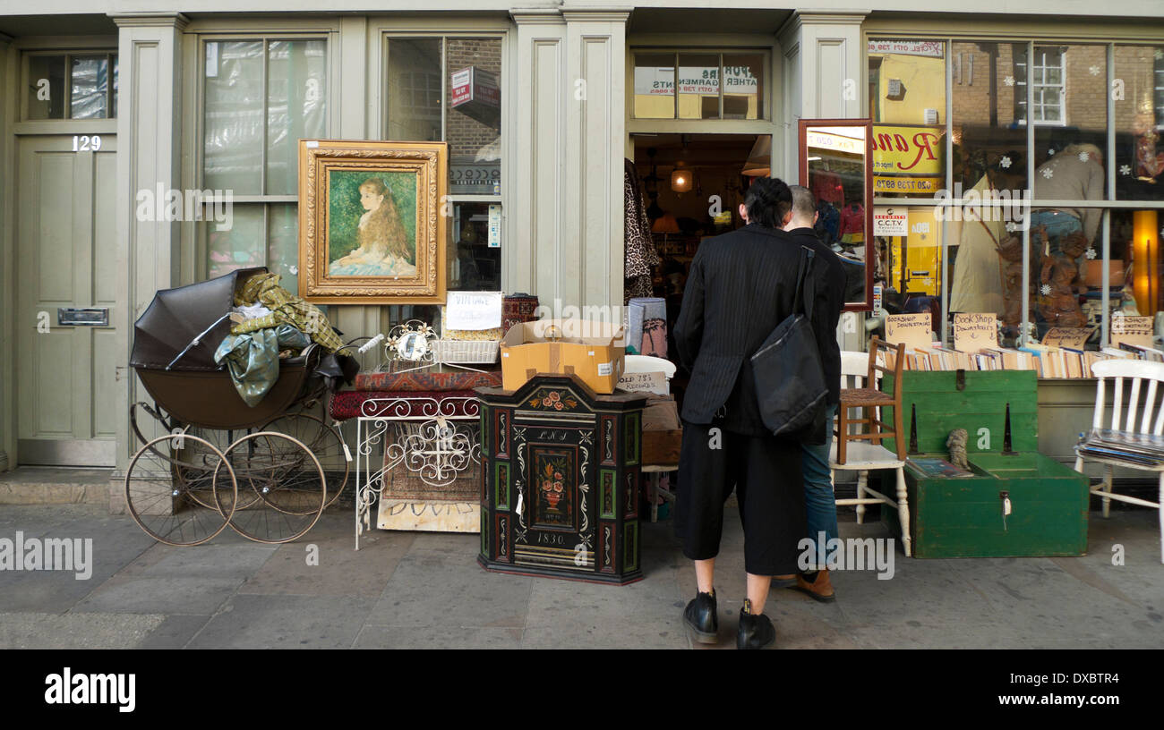 Fashionable young men browsing vintage antiques outside entrance to ...