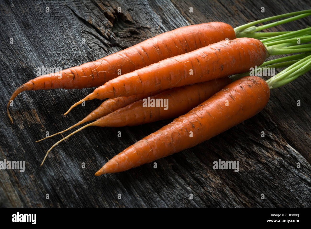 Organic raw carrots of rustic wood with greens Stock Photo - Alamy