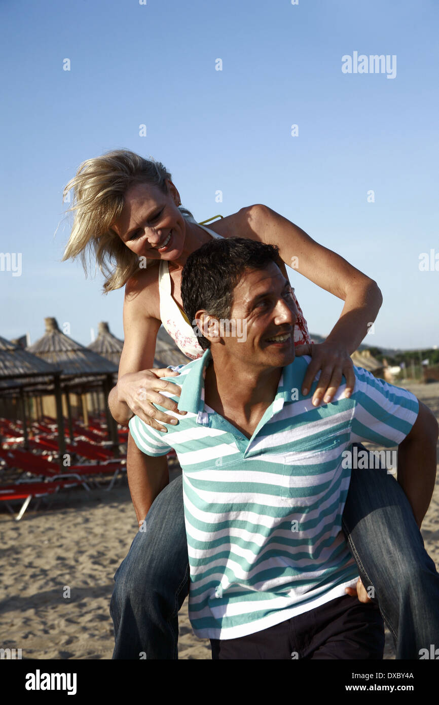 Couples on beach piggyback hi-res stock photography and images - Alamy