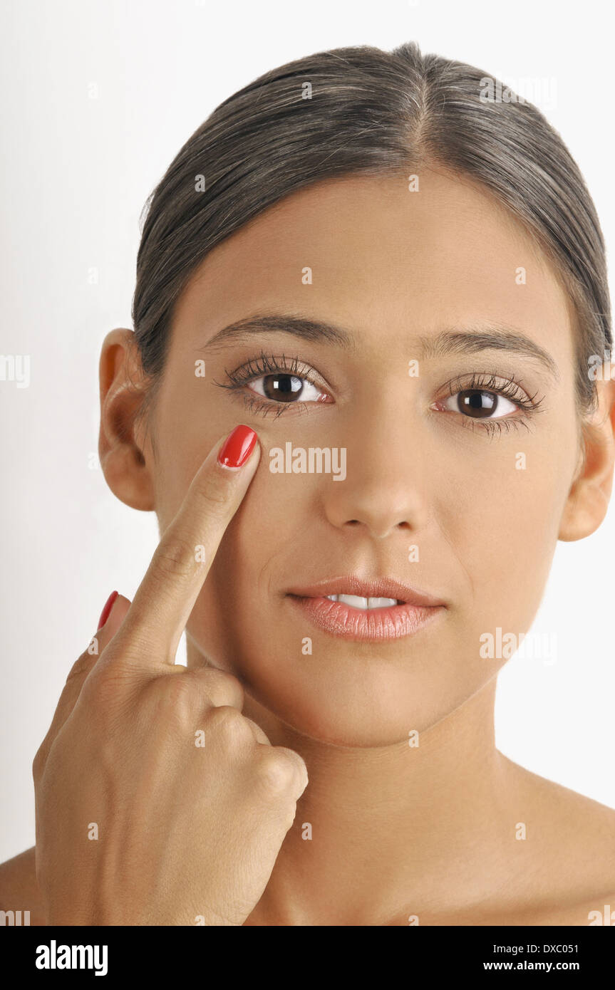 Female young adult, pointing to eye Stock Photo - Alamy
