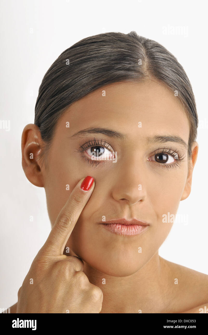 Female young adult, pointing to eye Stock Photo - Alamy