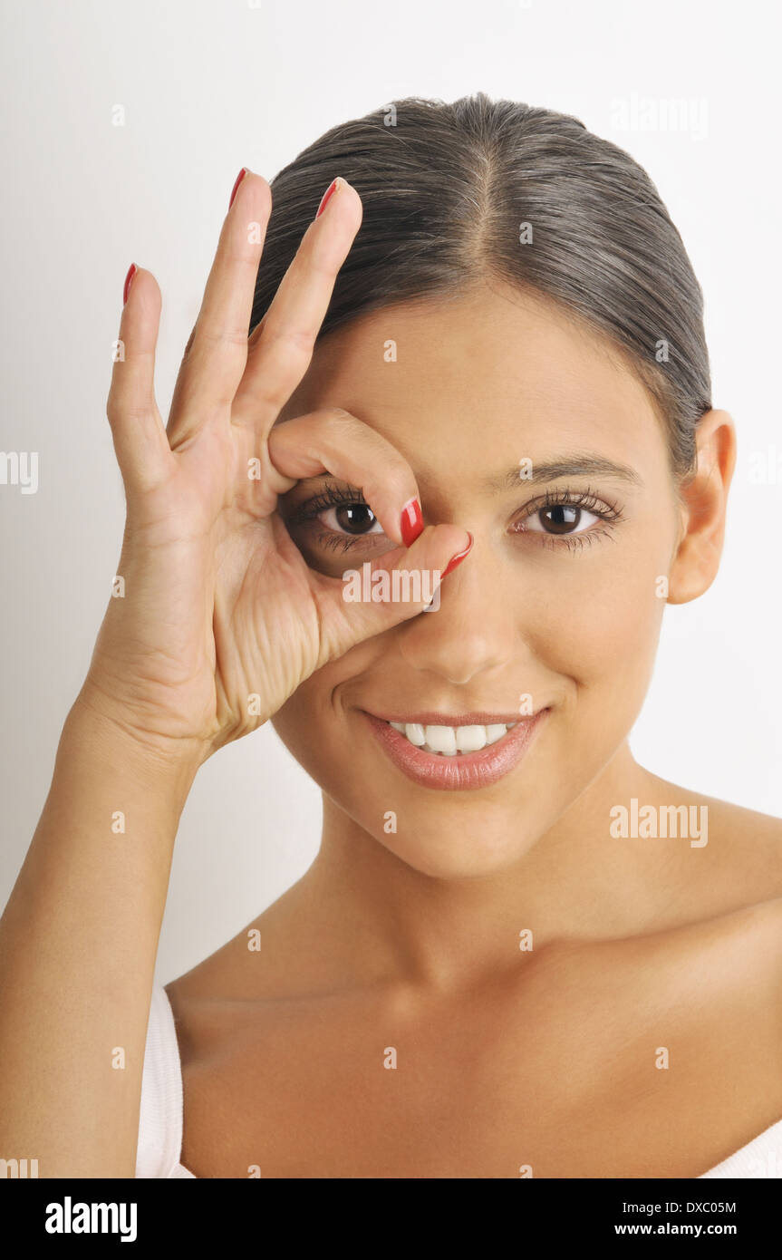 Female young adult, looking through fingers' hole Stock Photo - Alamy
